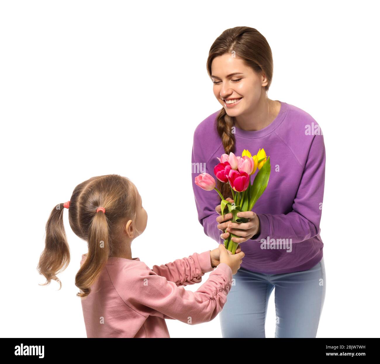 Cute little girl giving her mother bouquet of flowers, on white ...