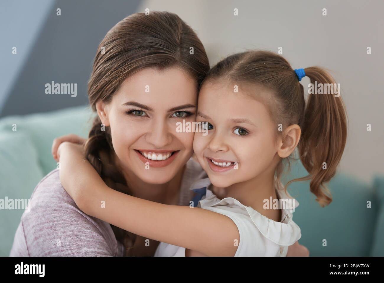 Portrait of happy mother and daughter hugging at home Stock Photo - Alamy