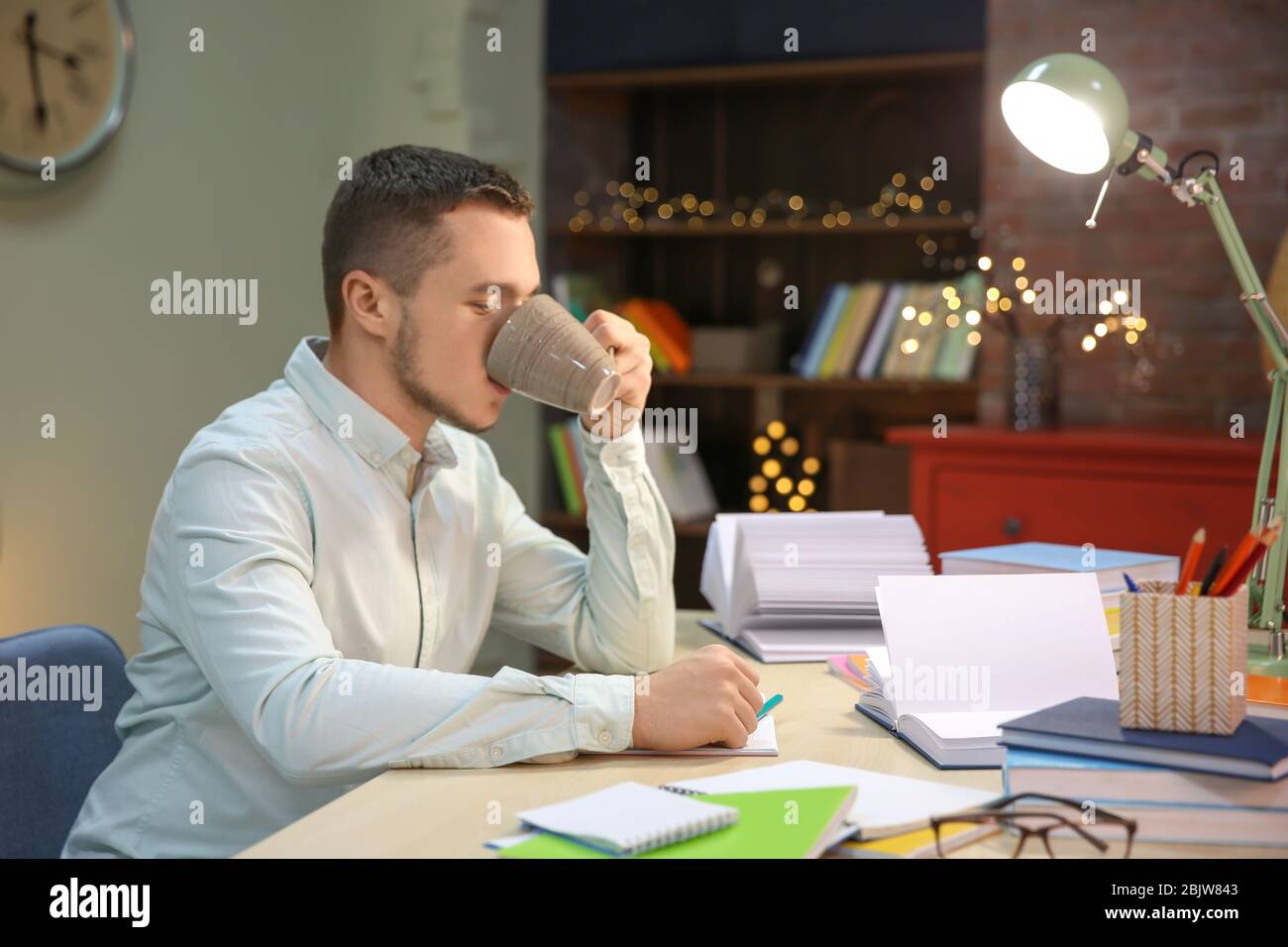 Student doing homework indoors late at night Stock Photo - Alamy