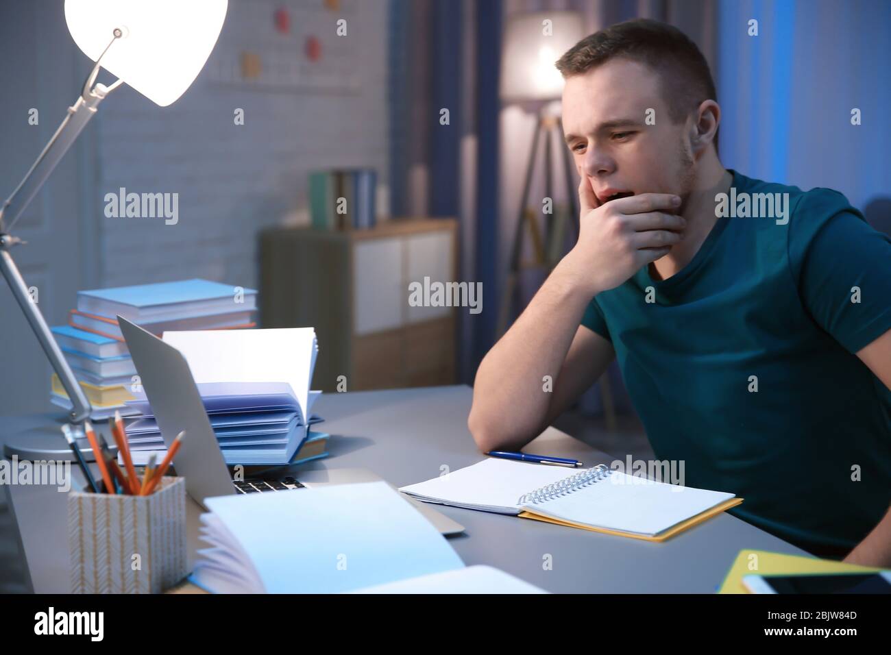 Tired student doing homework indoors late at night Stock Photo - Alamy