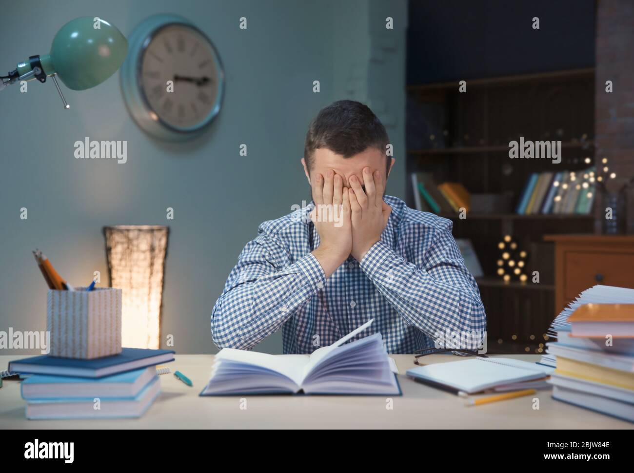 Student doing homework indoors late at night Stock Photo - Alamy