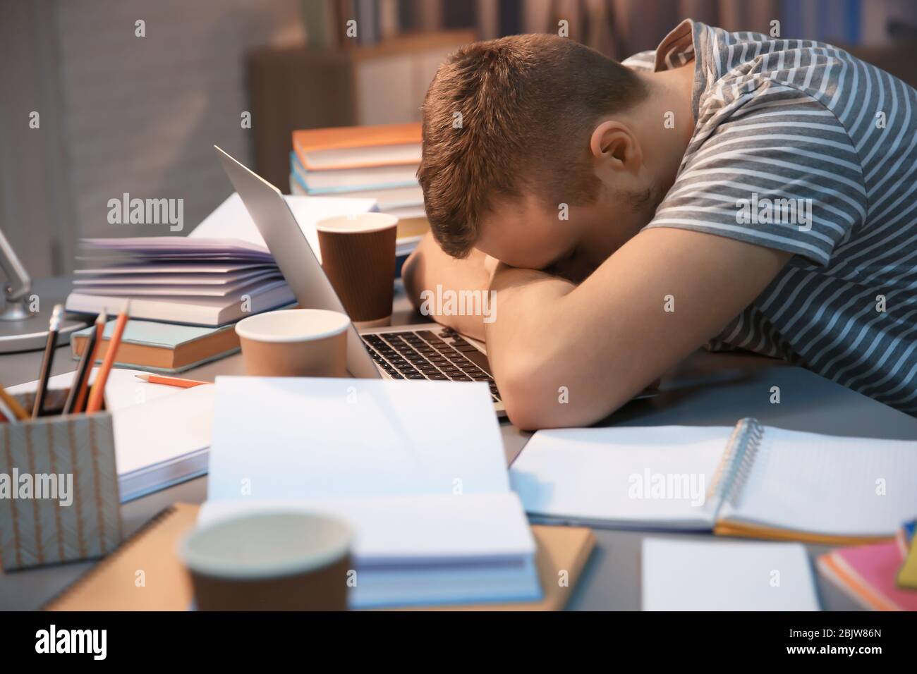 Tired student sleeping at table indoors Stock Photo - Alamy