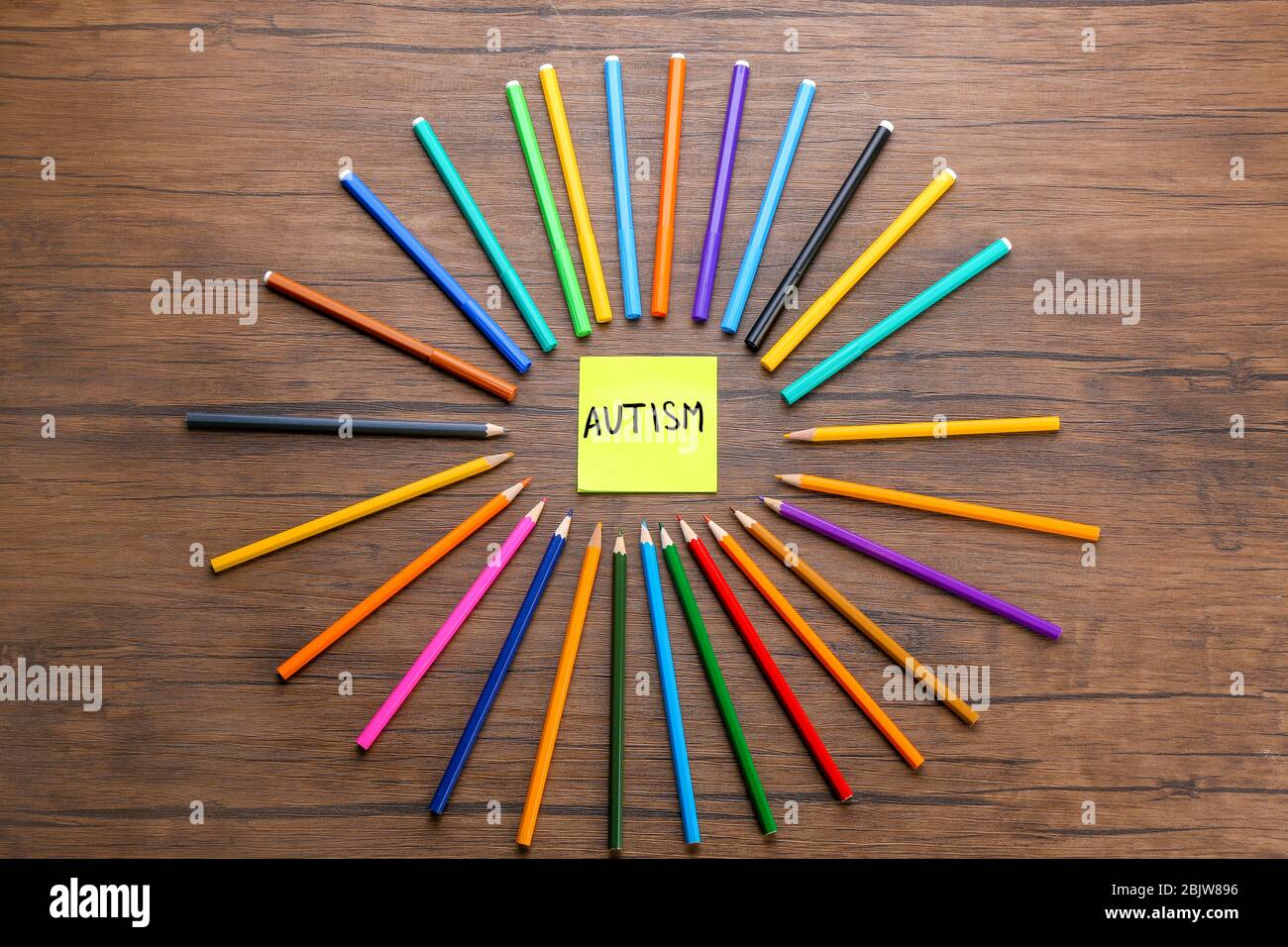 Colorful pencils, markers and note with word "Autism" on wooden ...