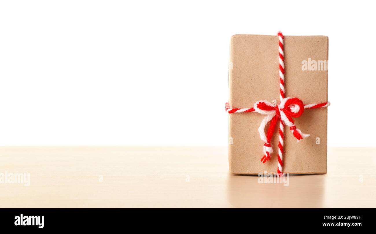 Parcel gift box on table against white background Stock Photo - Alamy