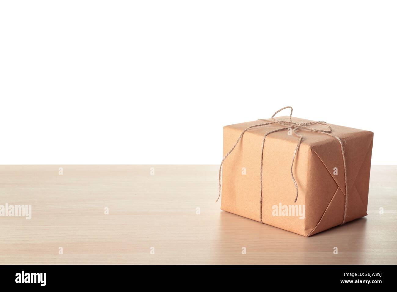 Parcel gift box on table against white background Stock Photo - Alamy