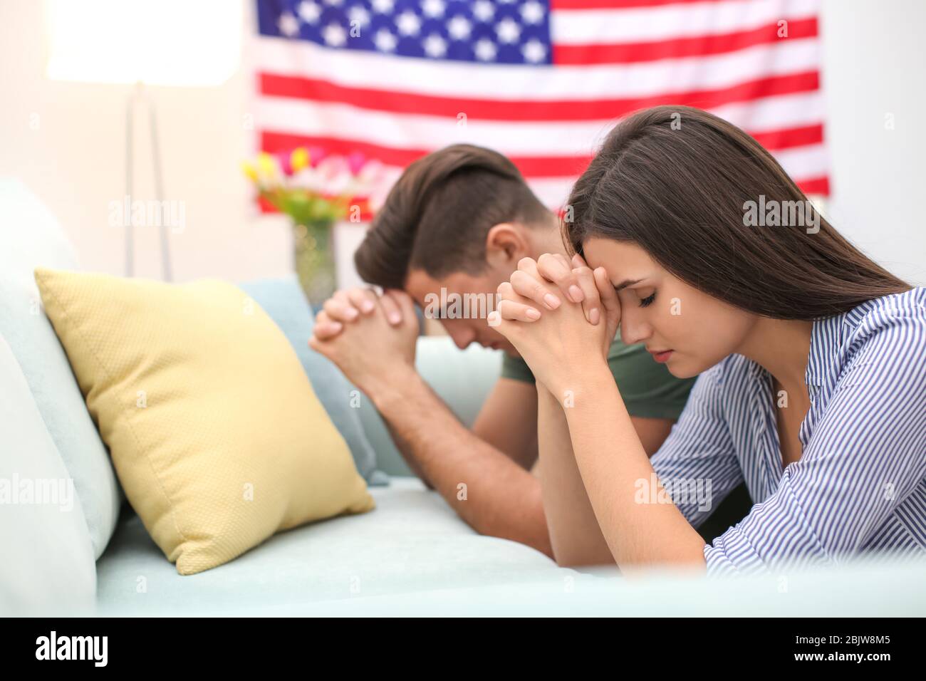Young couple praying for America at home Stock Photo - Alamy