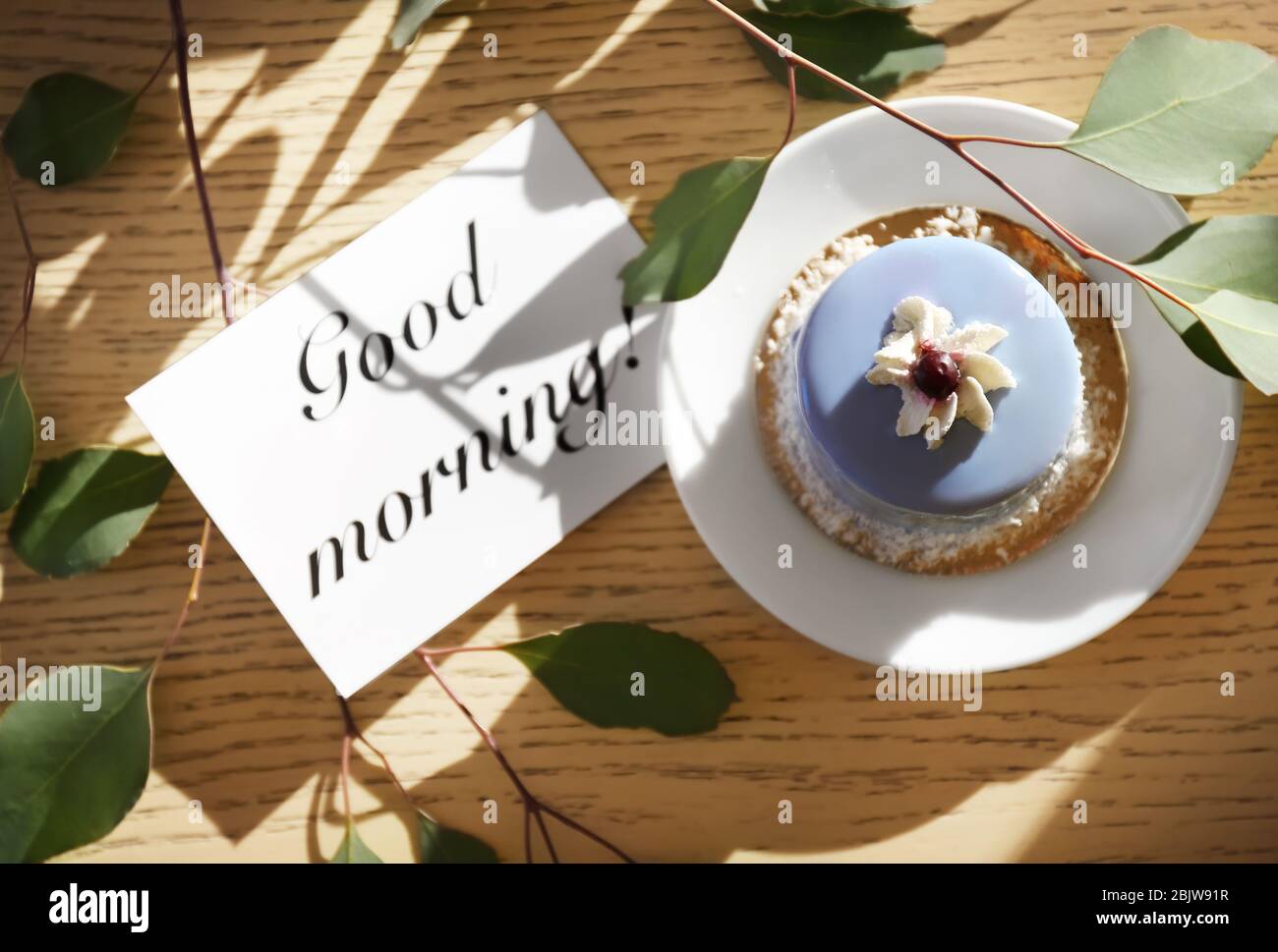 Delicious dessert and card with words "Good morning" on table. Tasty ...