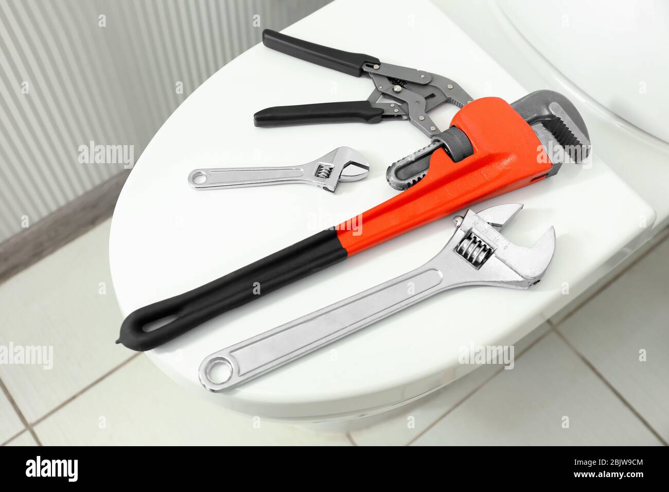 Plumber's tools on toilet seat lid Stock Photo - Alamy