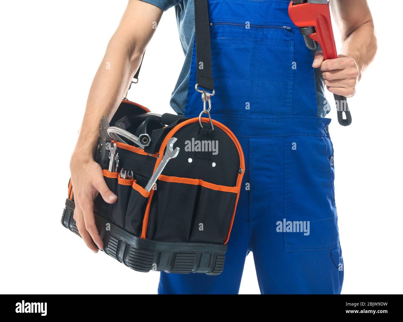 Young plumber in uniform with tool bag and pipe wrench on white ...
