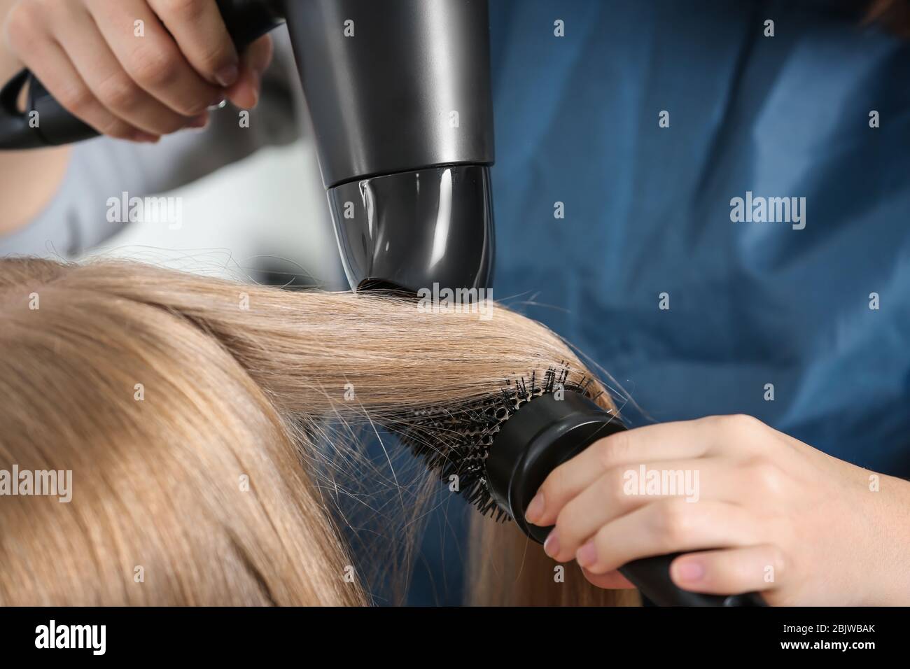 Professional hairdresser drying client's hair in beauty salon Stock ...