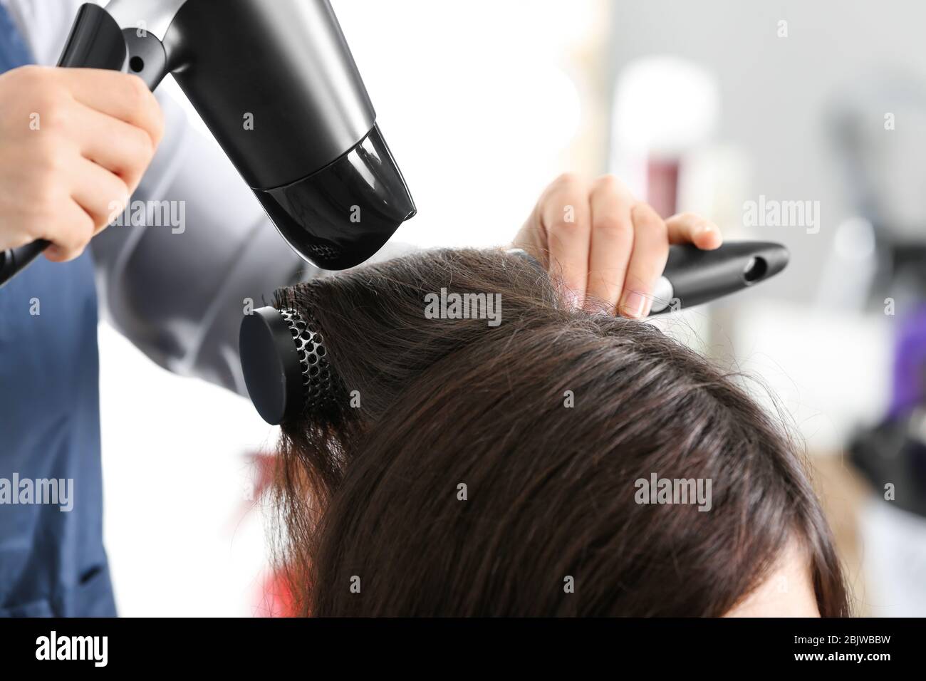 Professional hairdresser drying client's hair in beauty salon Stock ...