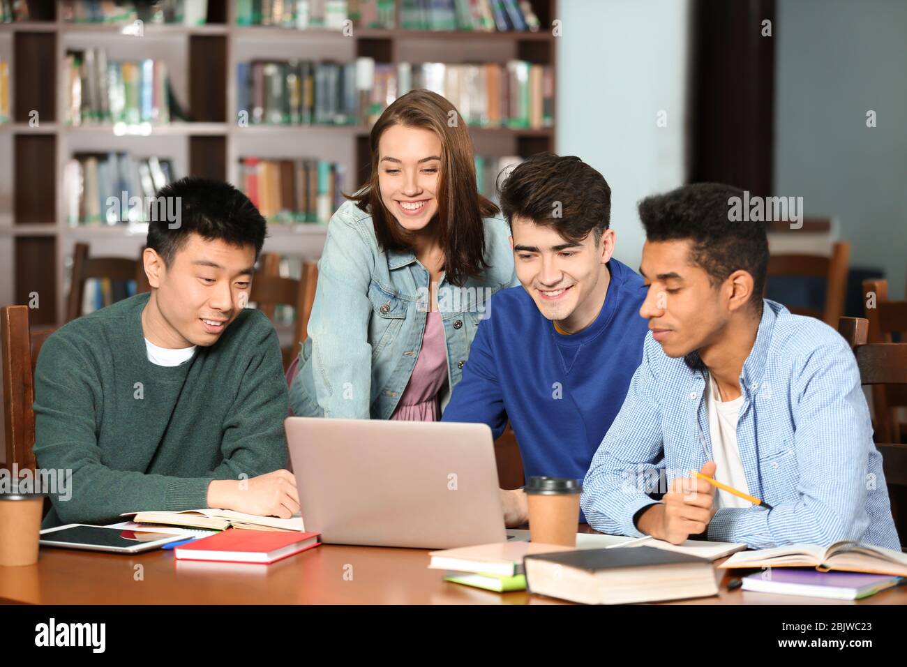 Group of students studying at table in library Stock Photo - Alamy