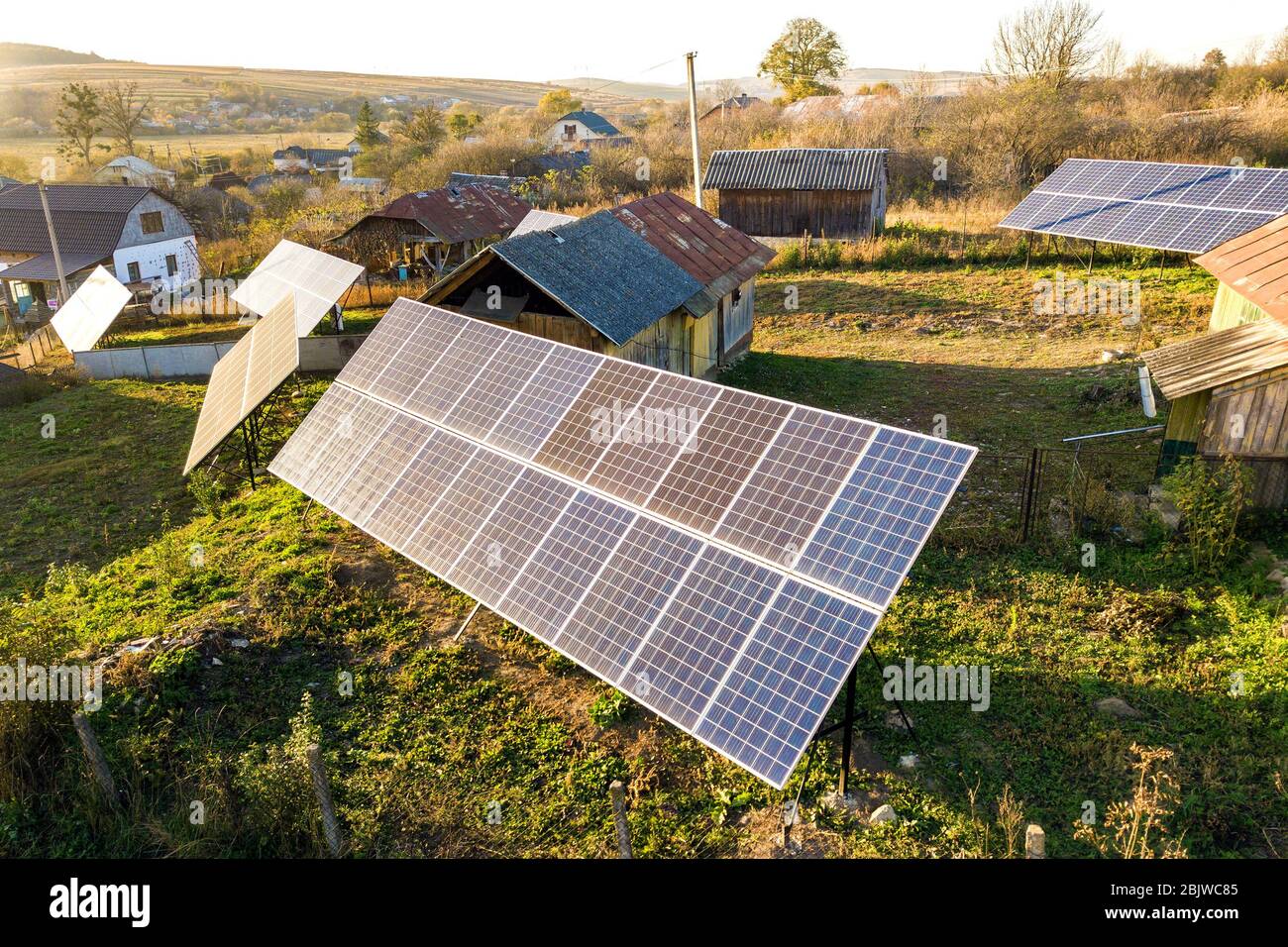 Aerial top down view of solar photo voltaic panels in green rural area ...
