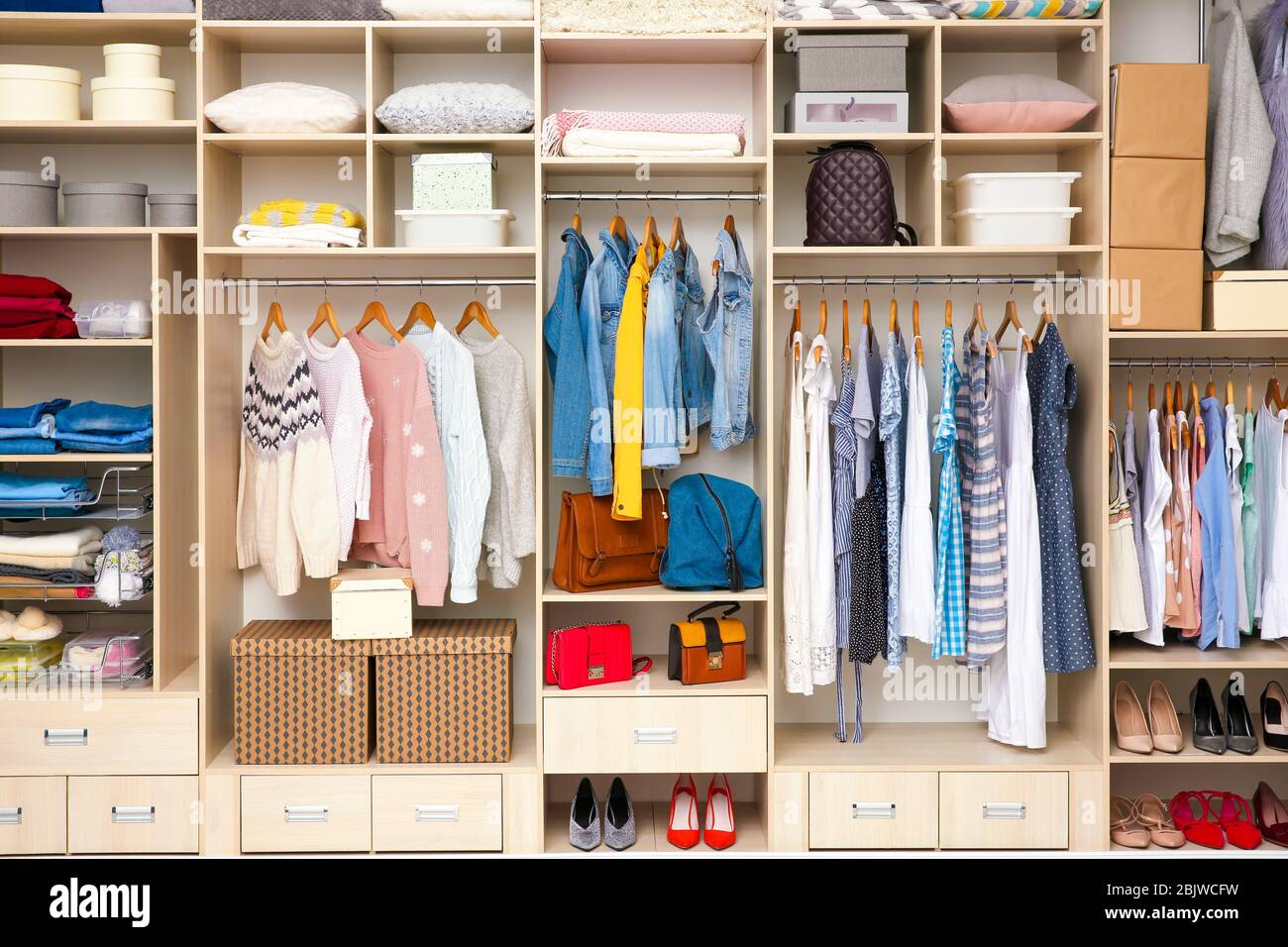 Large wardrobe with female clothes and accessories in dressing room ...
