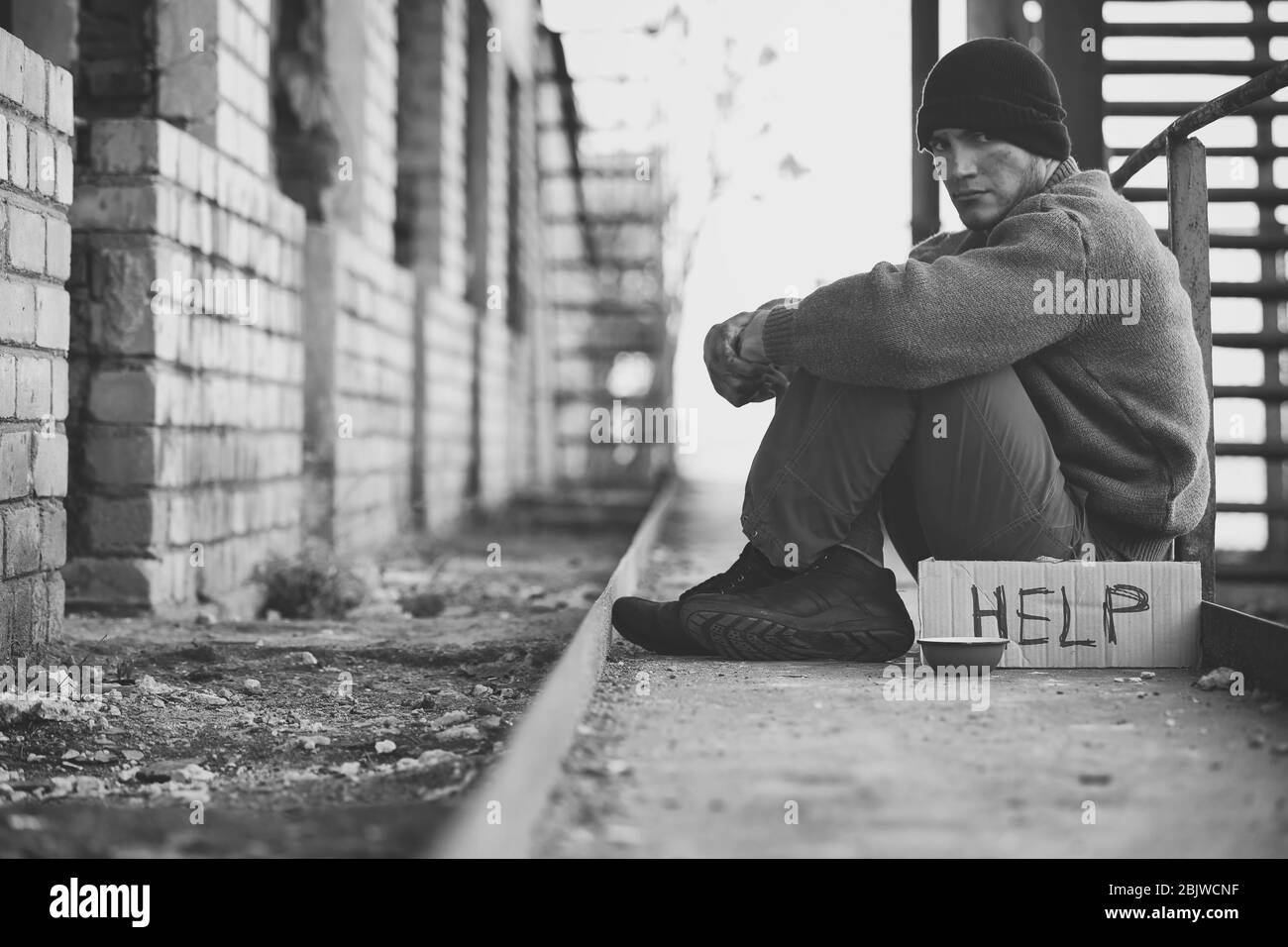 Homeless poor man sitting outdoors Stock Photo - Alamy
