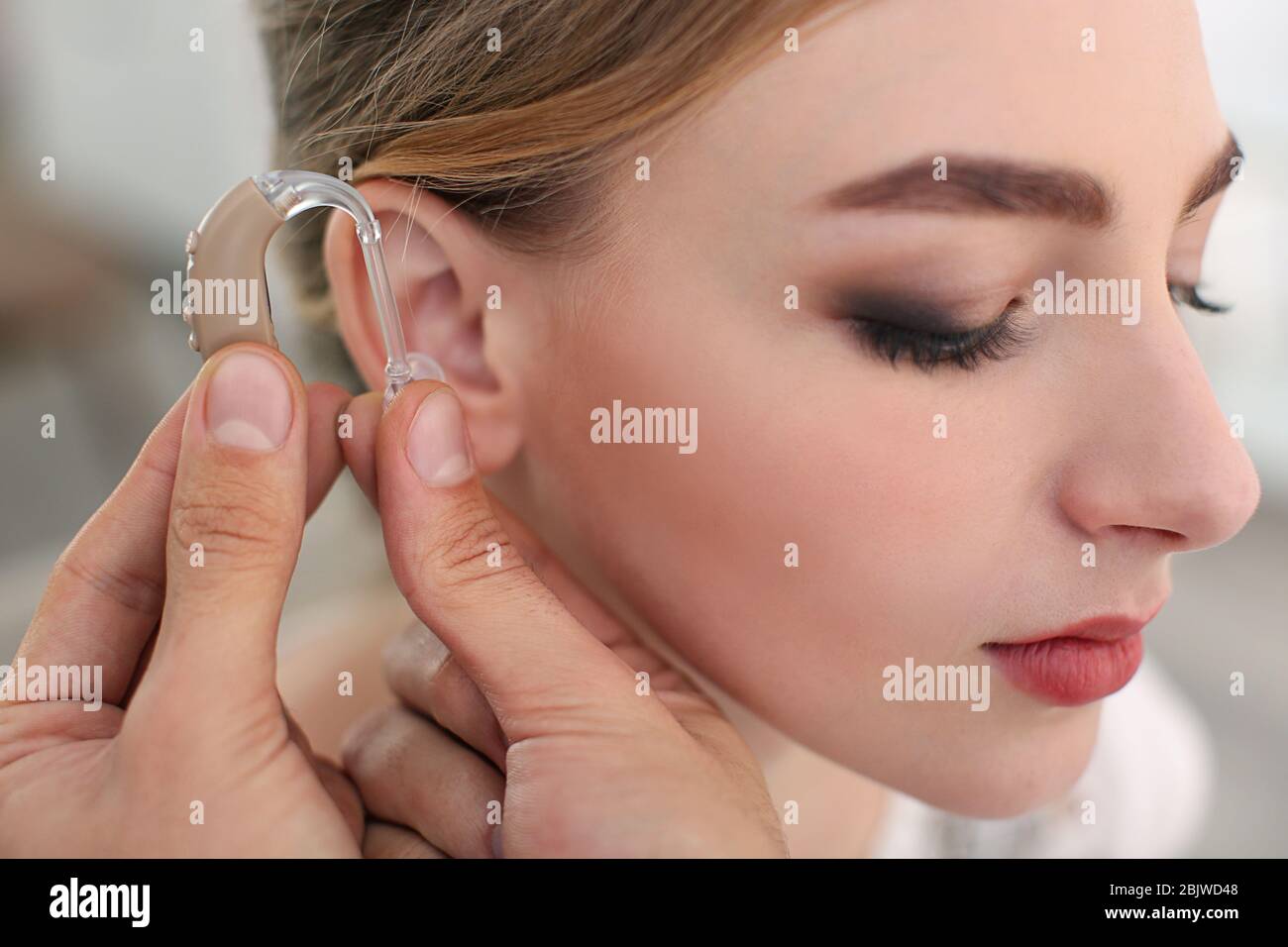 Otolaryngologist putting hearing aid in patient's ear in hospital Stock ...