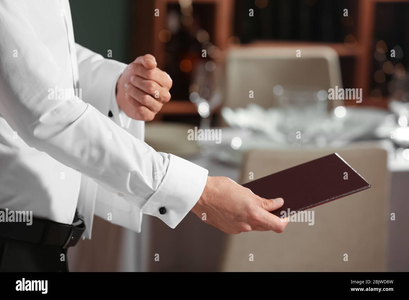 Waiter holding menu in restaurant Stock Photo - Alamy