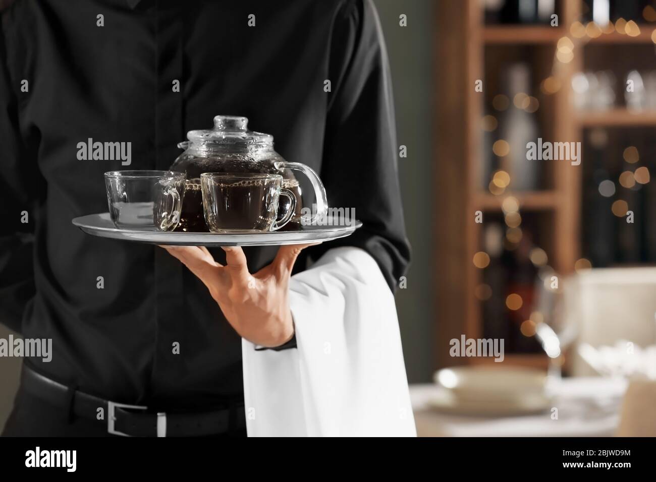 Waiter holding tray with glass teapot and cups in restaurant Stock ...
