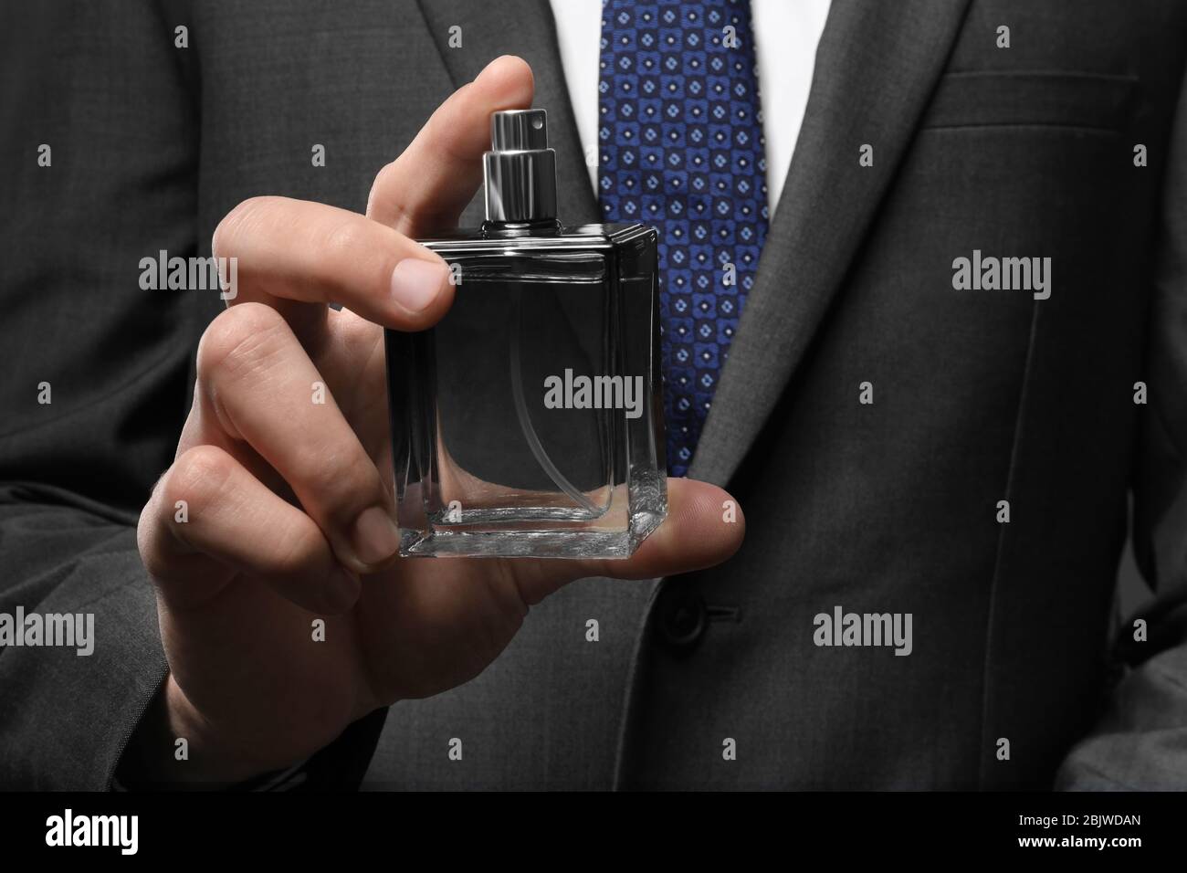 Handsome man in formal suit and with bottle of perfume, closeup Stock ...