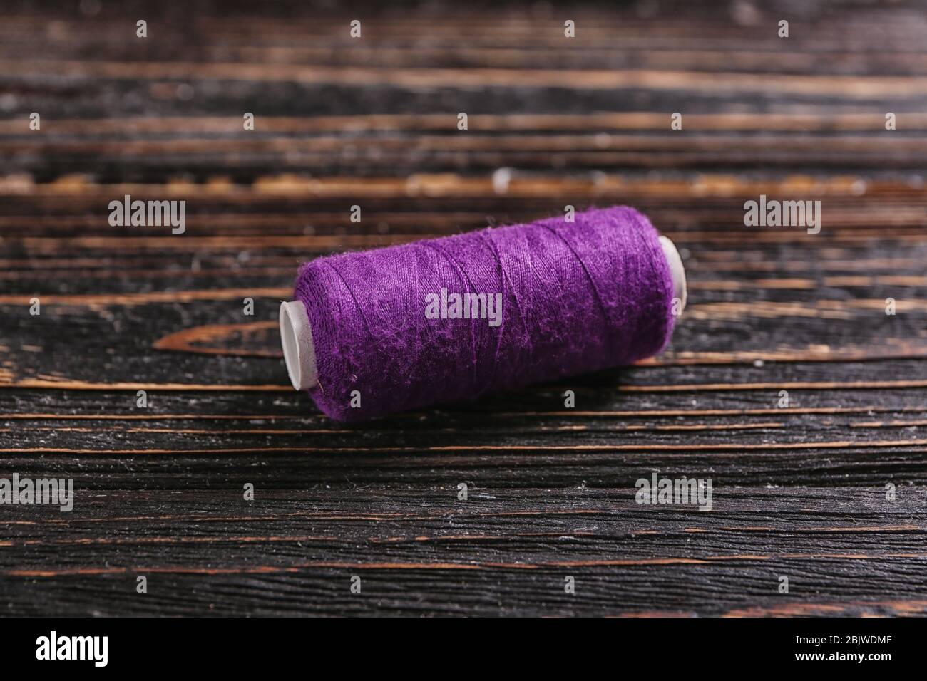 Color sewing thread on wooden background Stock Photo - Alamy