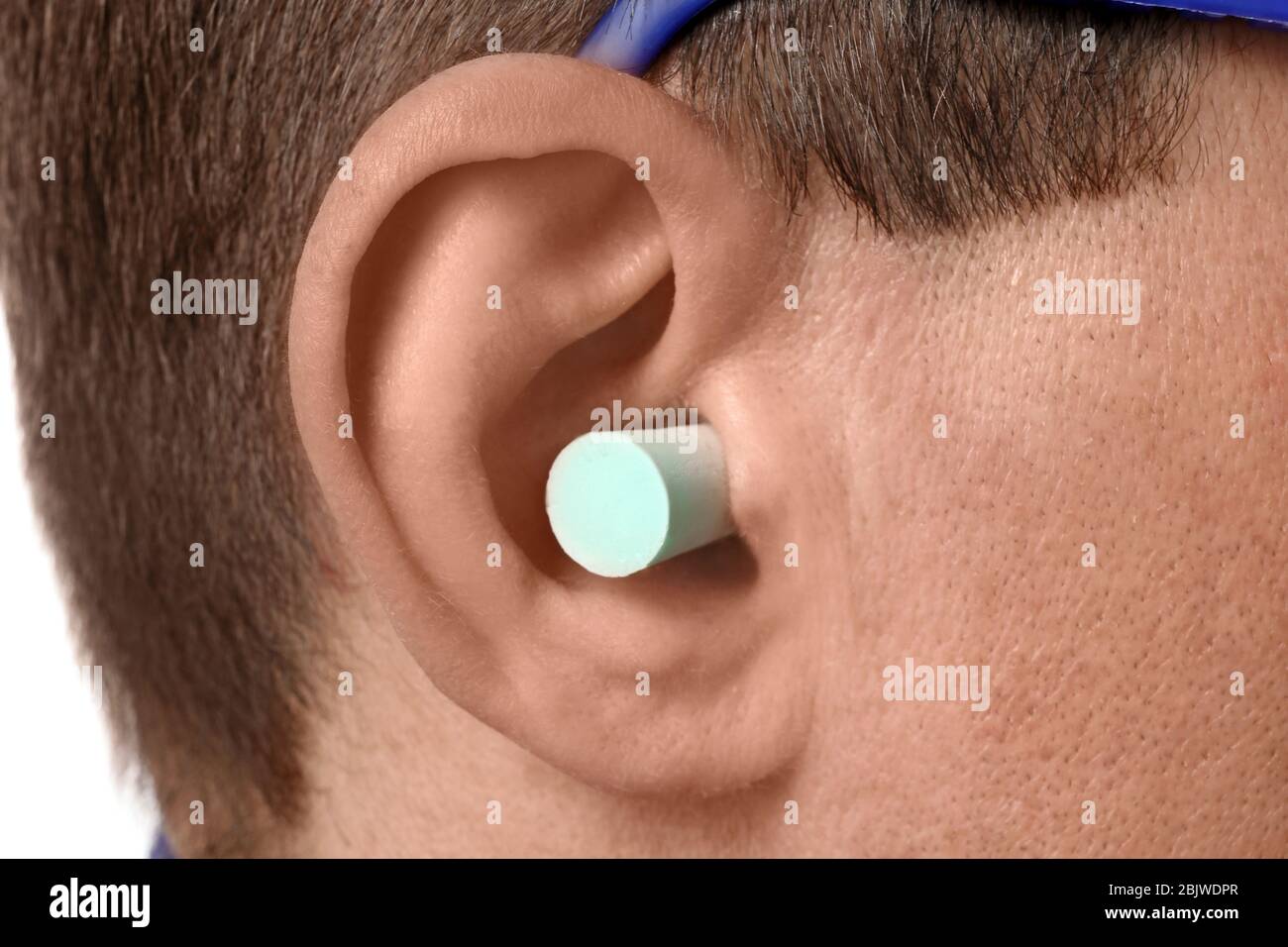 Male worker with ear plug, closeup. Health and safety at workplace ...