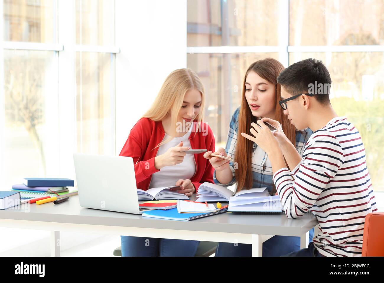 Students making cheat sheets for exam indoors Stock Photo - Alamy