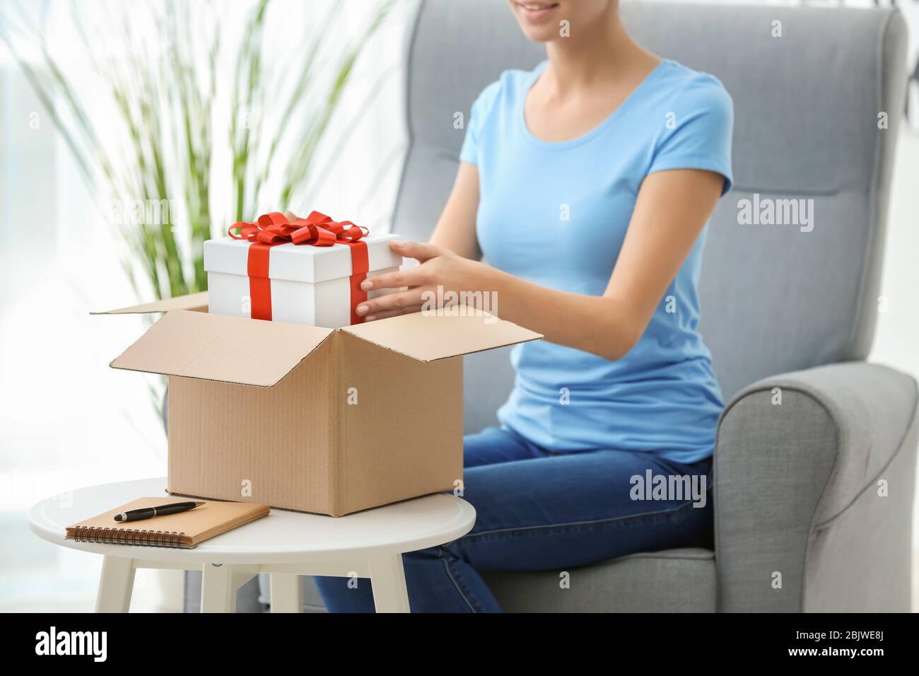 Woman received gift in parcel box at home Stock Photo - Alamy