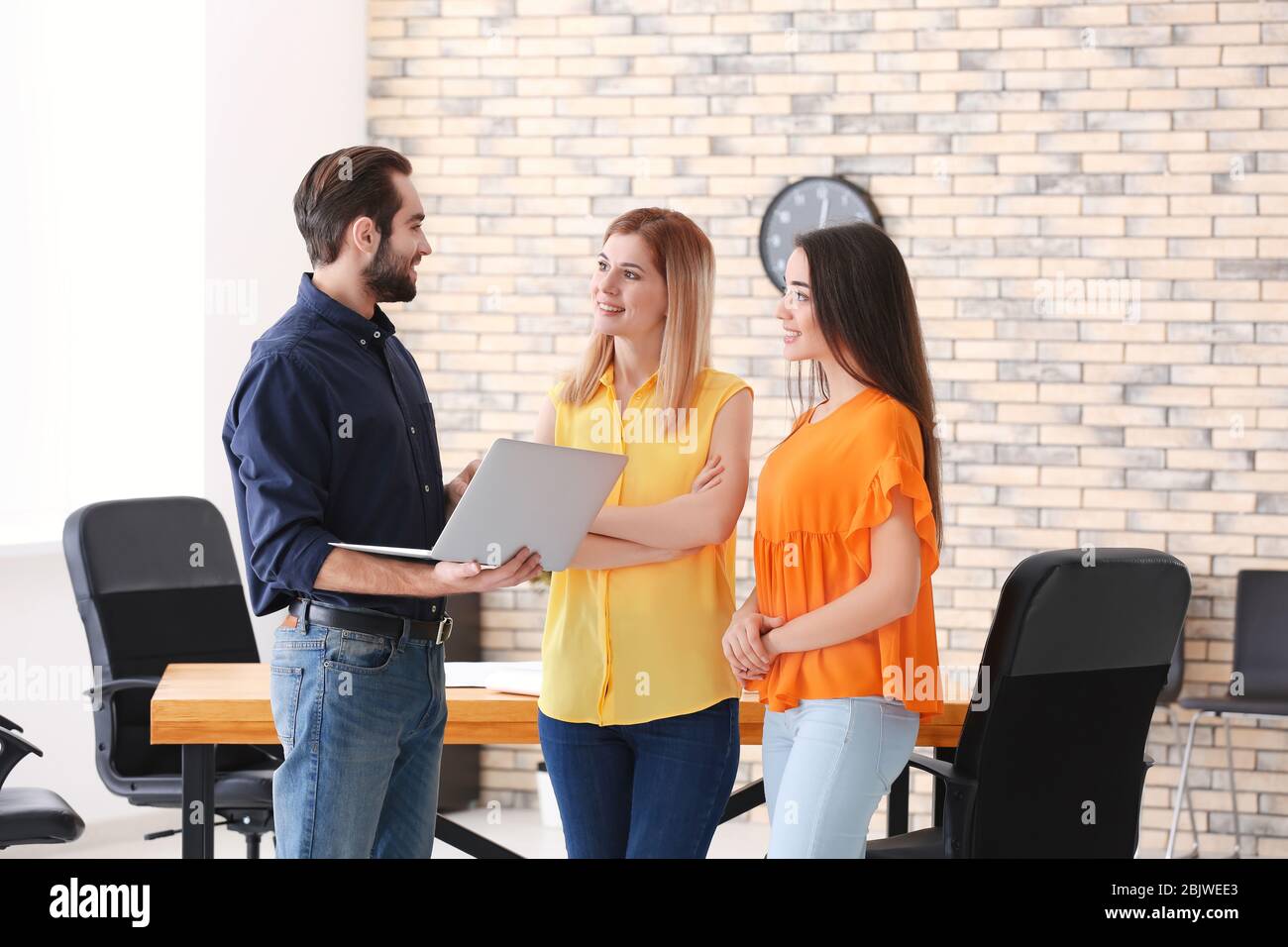 Real estate agent with trainee and client in office Stock Photo - Alamy