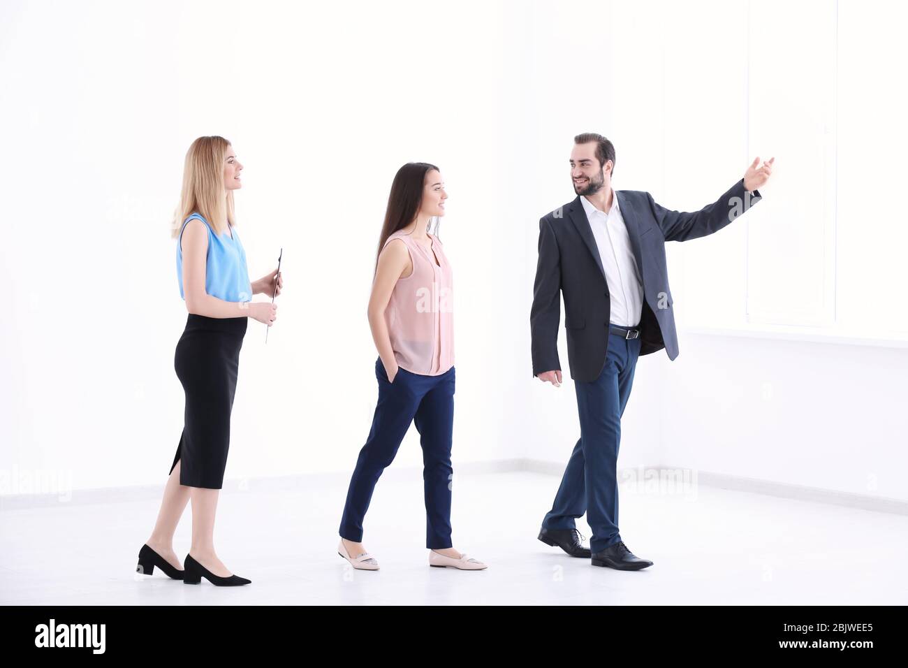 Real estate agent with trainee showing apartment to client Stock Photo ...