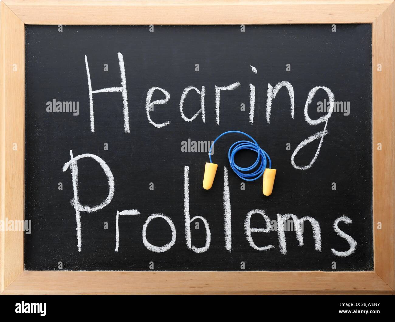 Earplugs and chalkboard with words HEARING PROBLEMS on white background ...