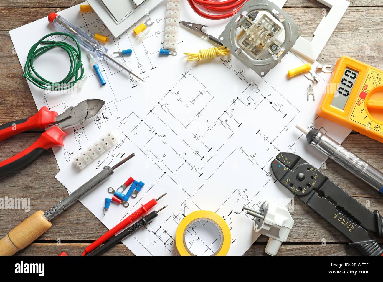 Different electrical tools and circuit diagram on wooden background ...