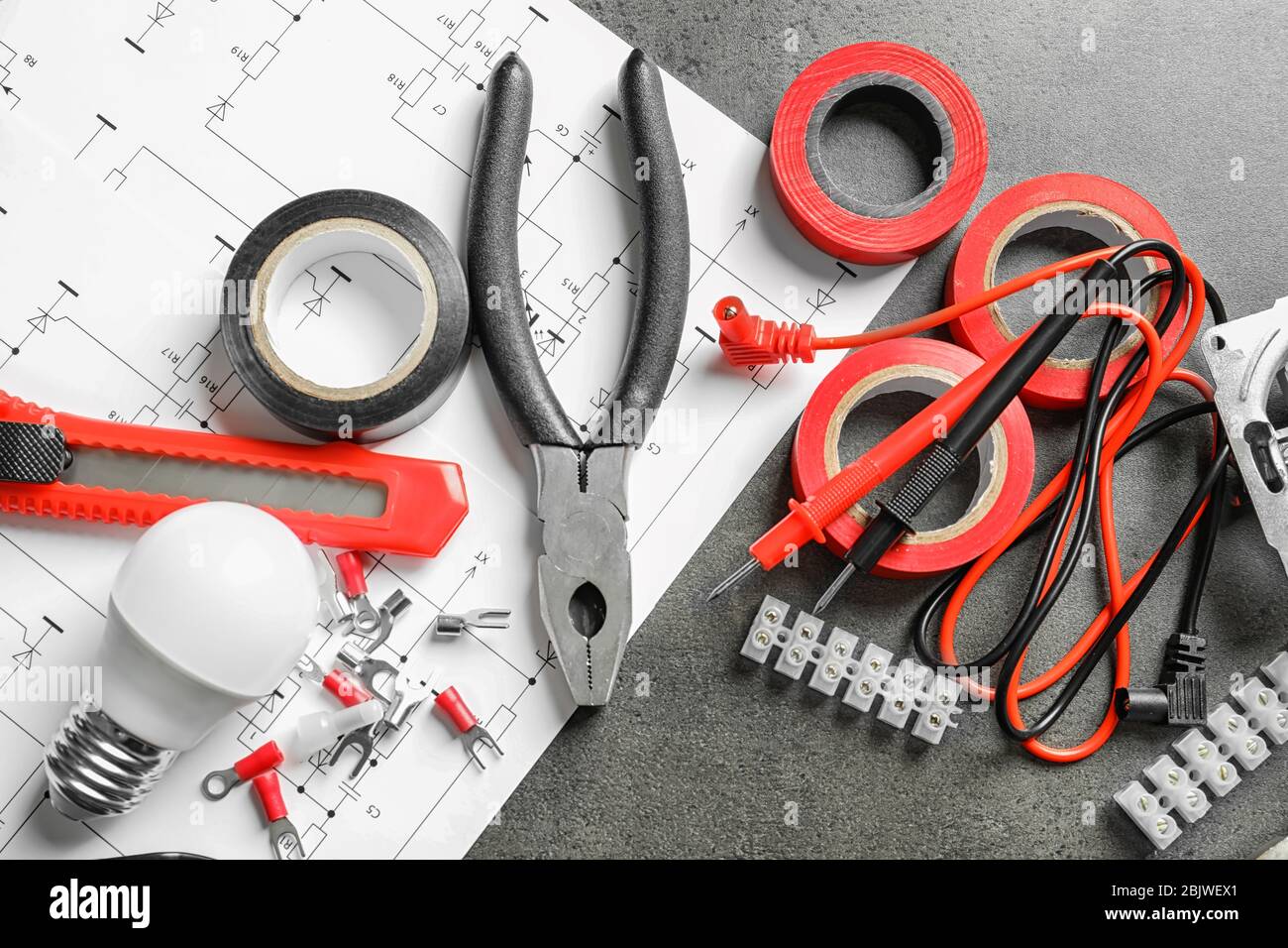Different electrical tools and circuit diagram on grey background Stock ...