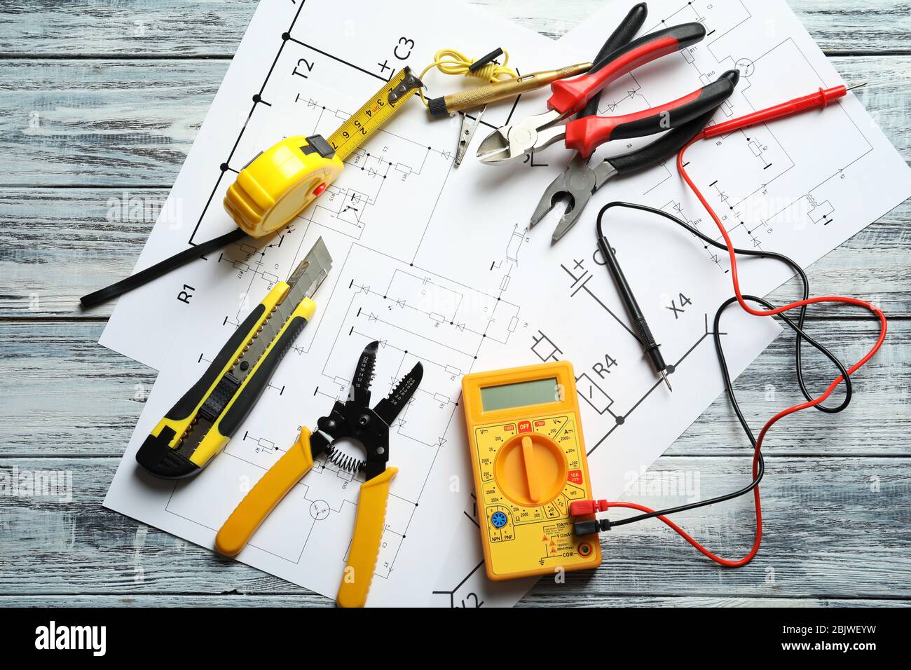 Different electrical tools and circuit diagram on wooden background ...