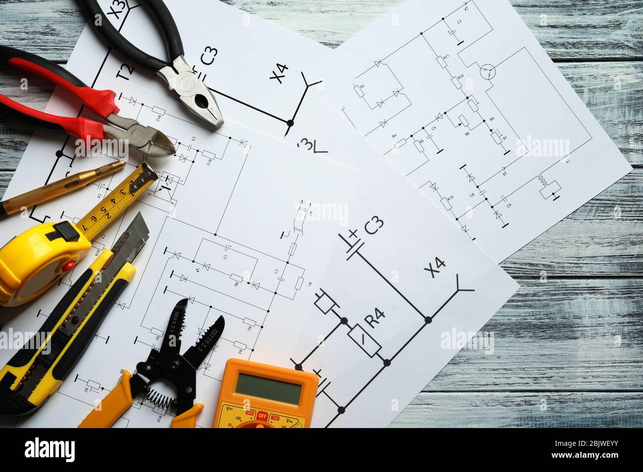 Different electrical tools and circuit diagram on wooden background ...