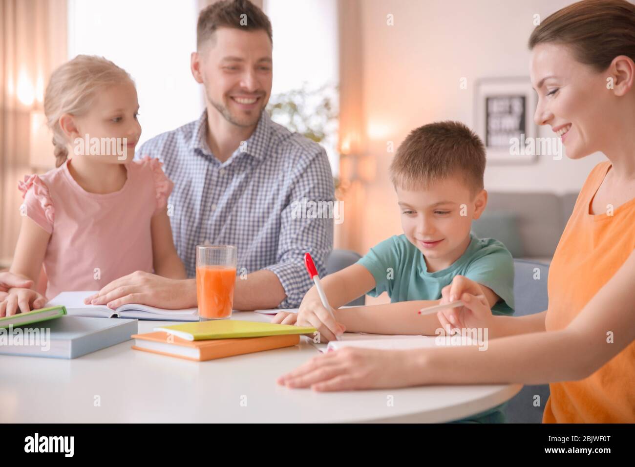 Little children with parents doing homework at home Stock Photo - Alamy