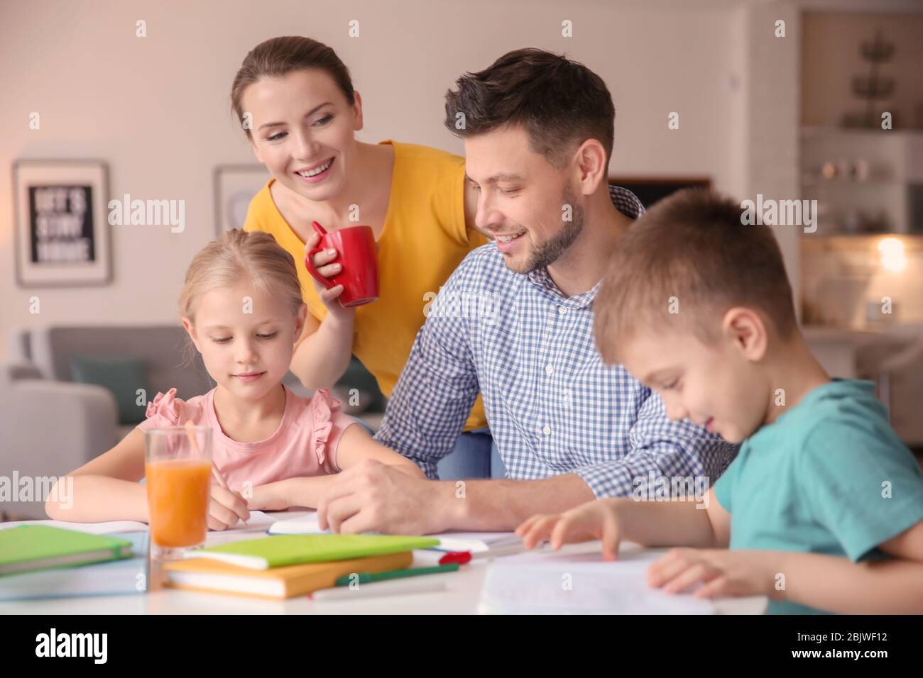 Little children with parents doing homework at home Stock Photo - Alamy