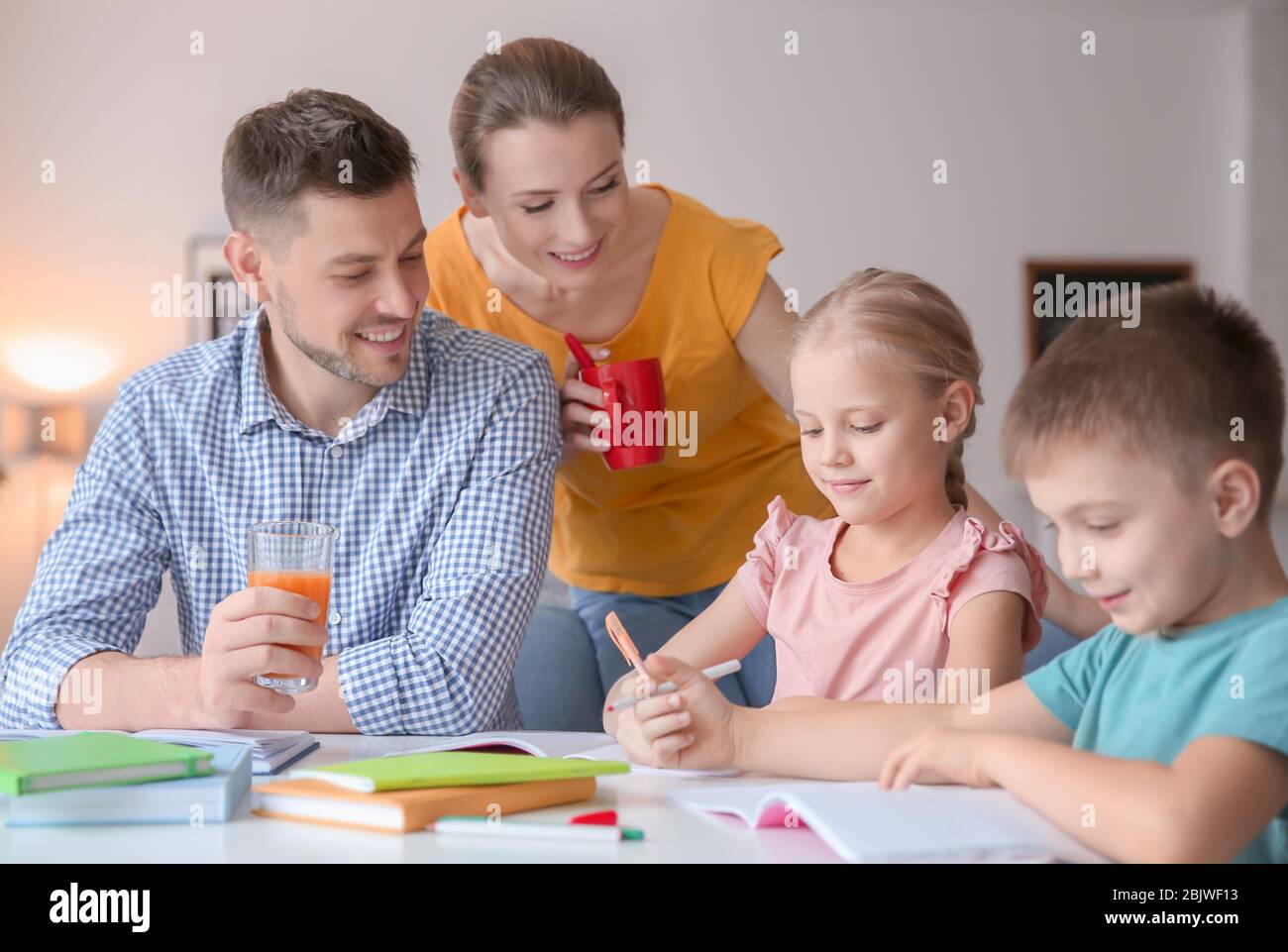 Little children with parents doing homework at home Stock Photo - Alamy