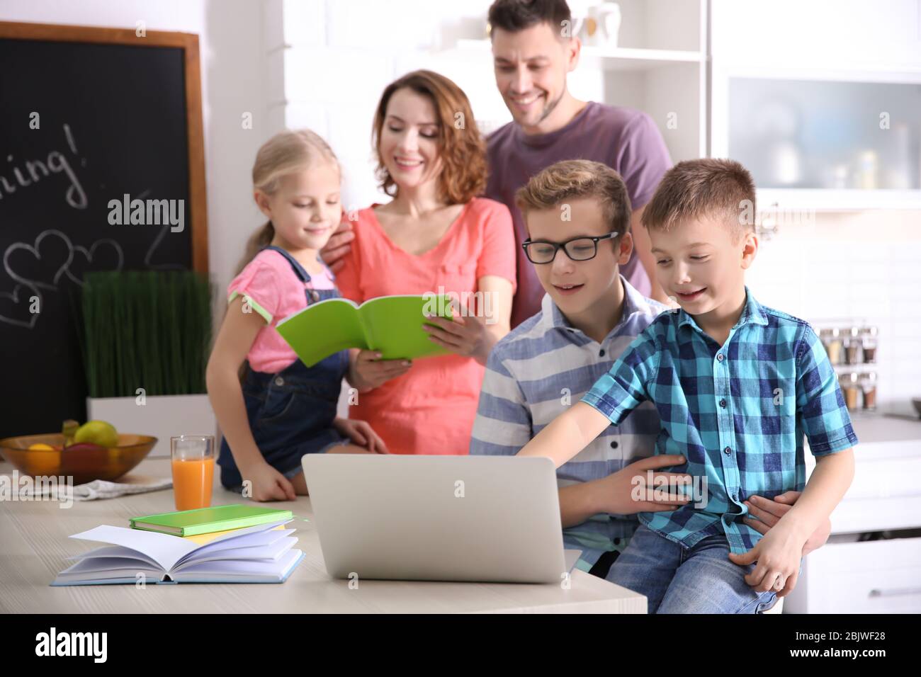 Children with parents doing homework at home Stock Photo - Alamy