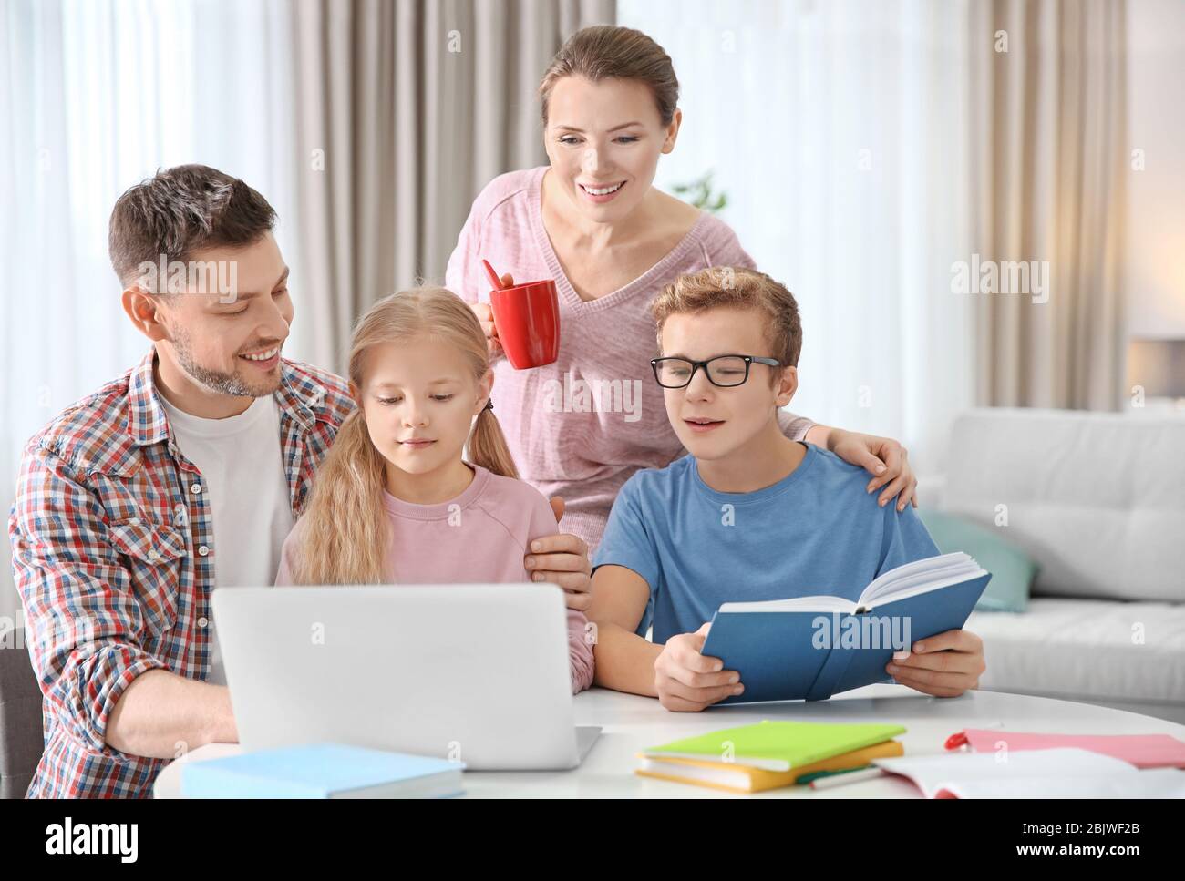 Children with parents doing homework at home Stock Photo - Alamy