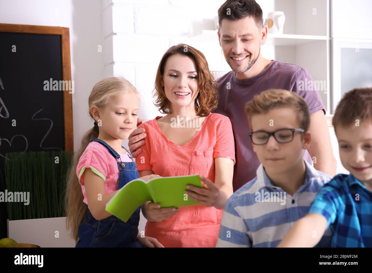 Children with parents doing homework at home Stock Photo - Alamy