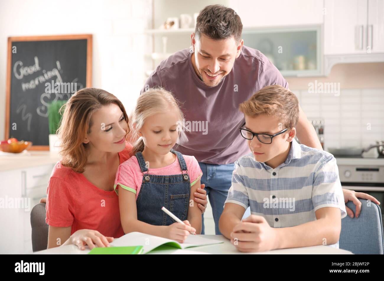 Children with parents doing homework at home Stock Photo - Alamy