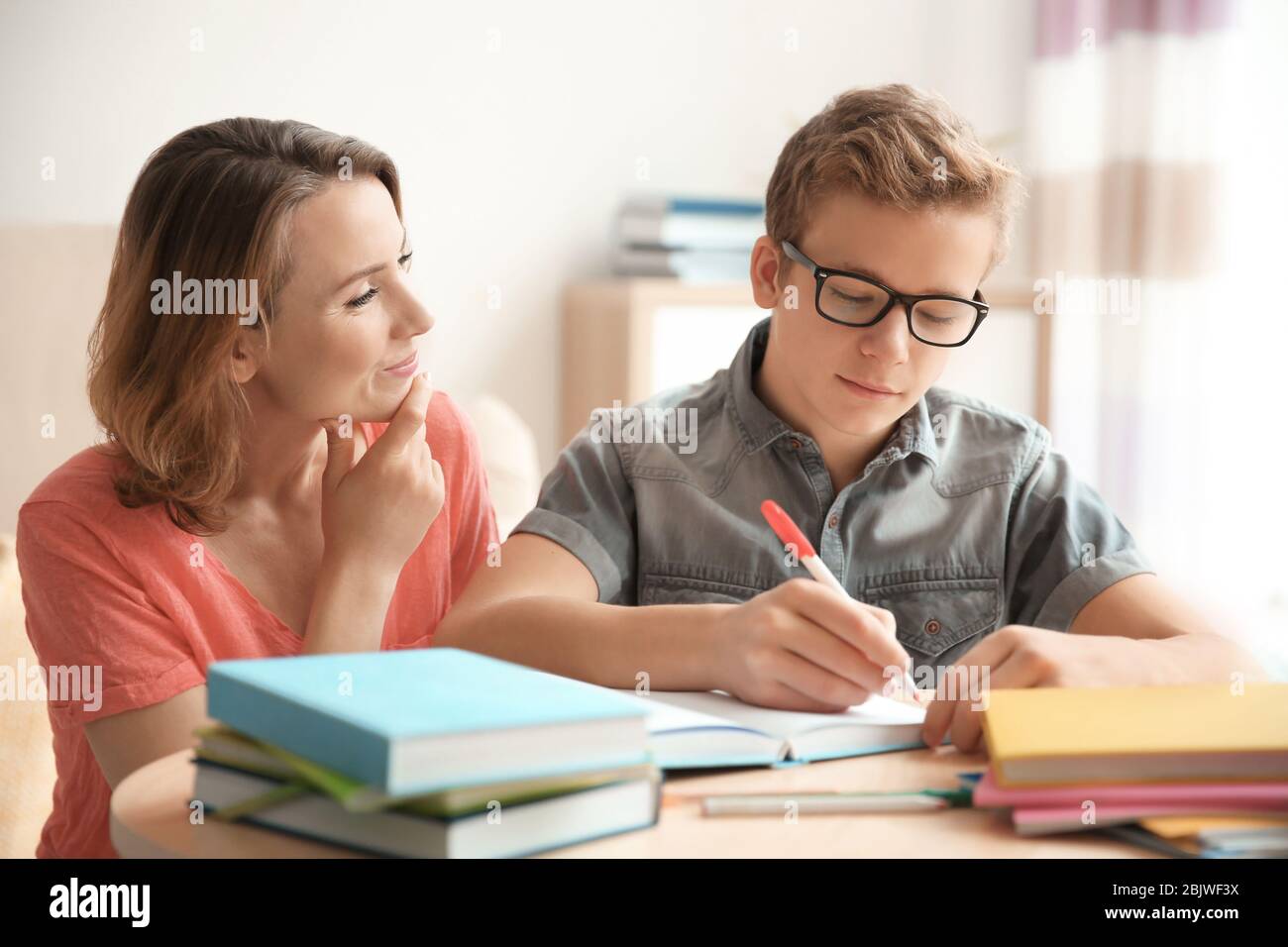 Teenager with mother doing homework at home Stock Photo - Alamy