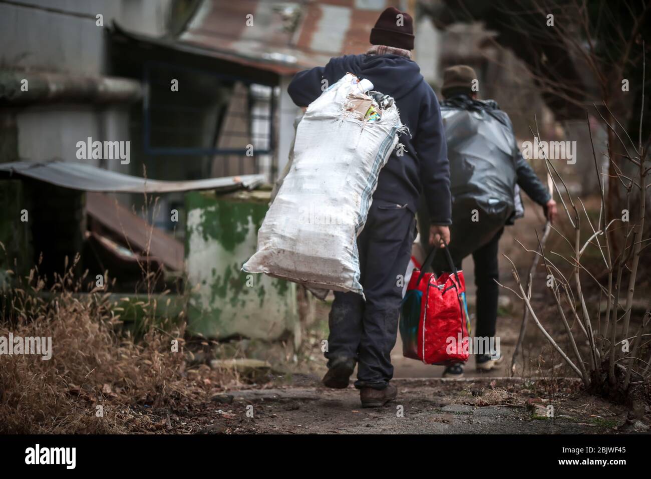 Poor people with bags of garbage outdoors Stock Photo - Alamy