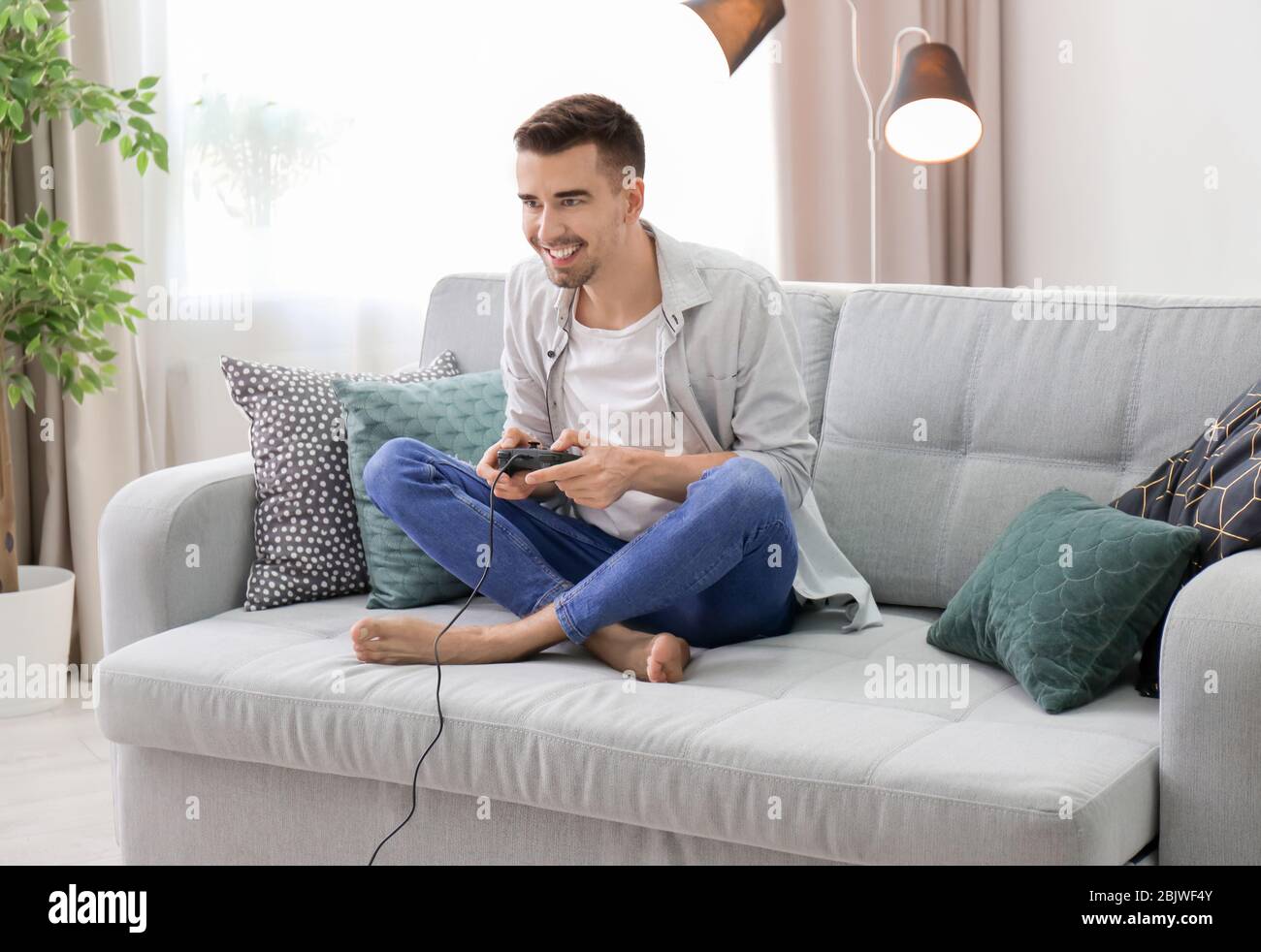 Young man playing video games at home Stock Photo - Alamy