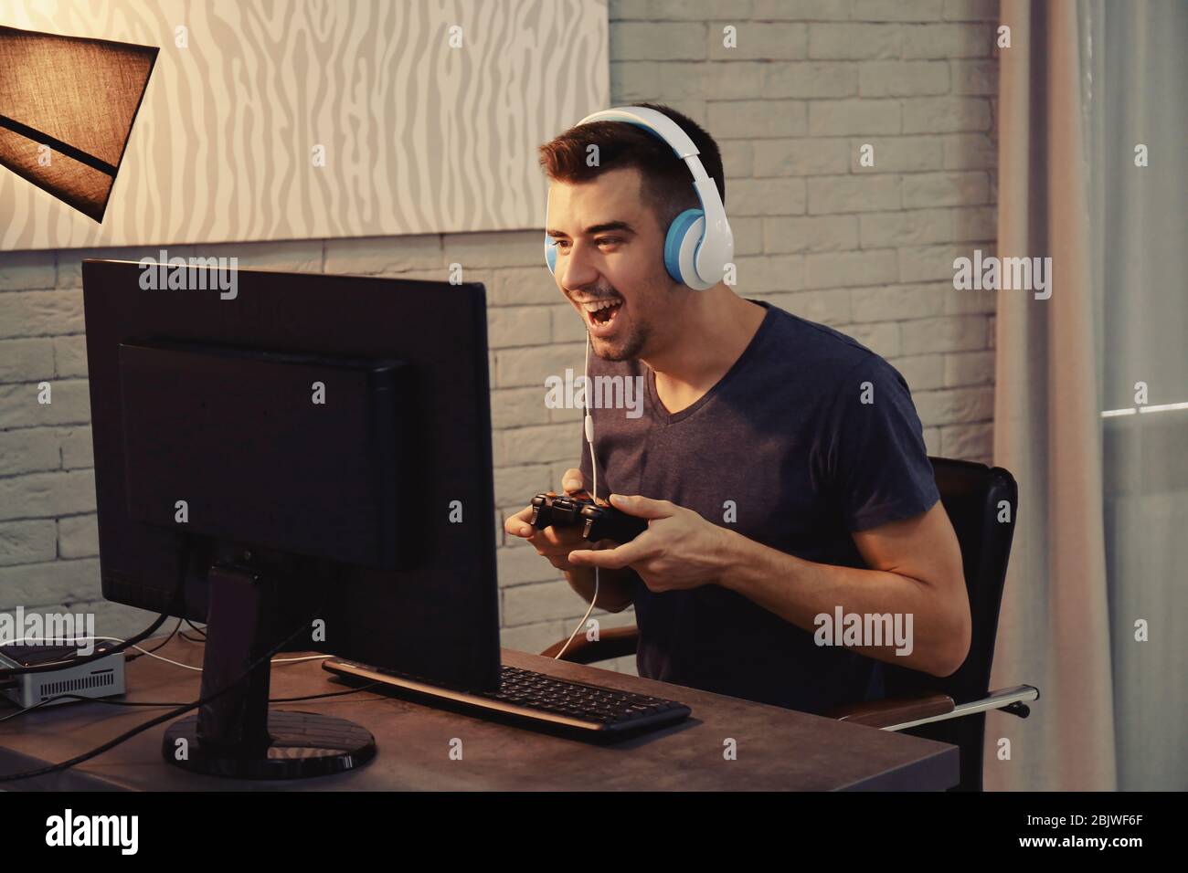 Young man playing video games at home Stock Photo - Alamy