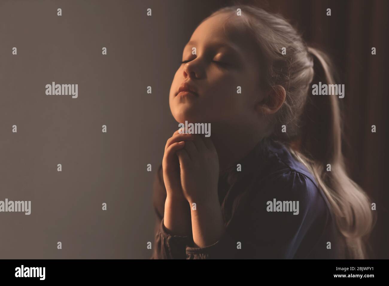 Religious Christian girl praying indoors Stock Photo - Alamy