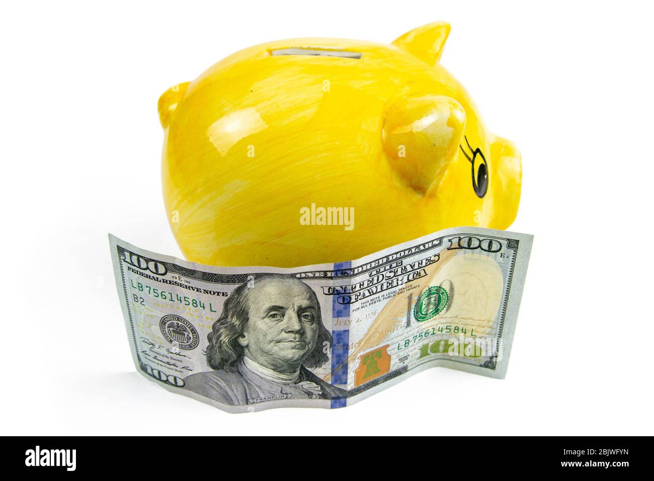 Pink piggy bank with one hundred US dollar bills isolated on a white ...