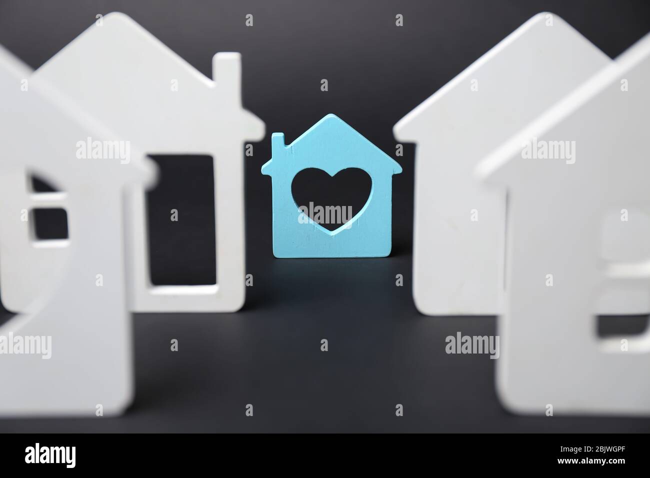 House figures and one different on dark background Stock Photo - Alamy