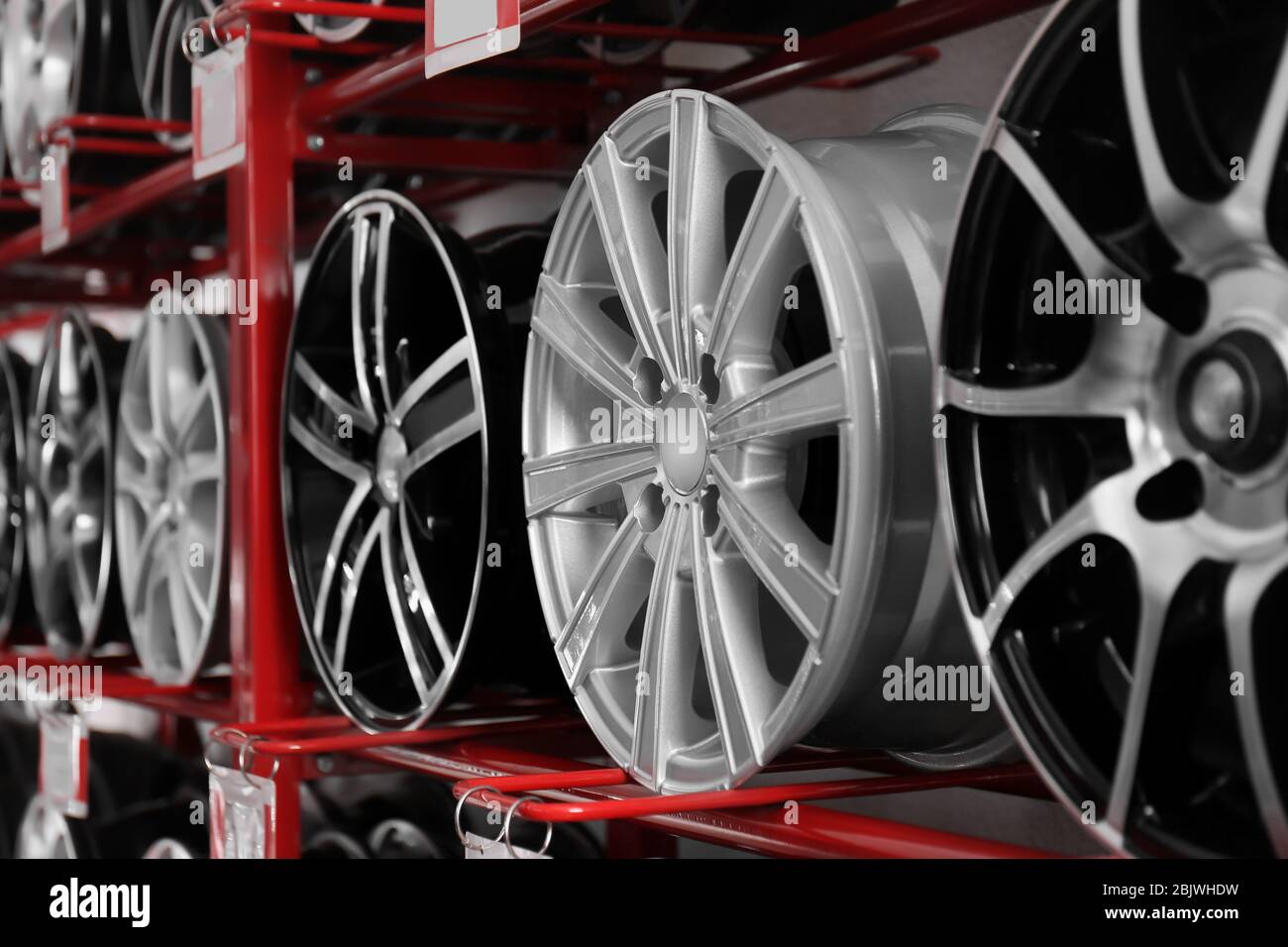 Stand with alloy wheels in modern tire store Stock Photo - Alamy