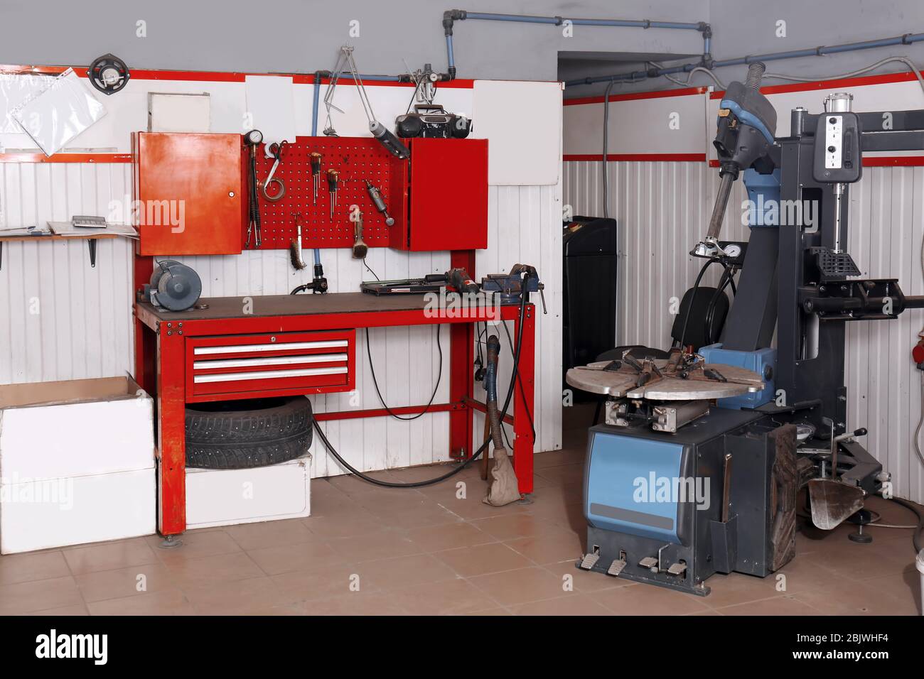Car service center interior with modern workbench and tire fitting ...